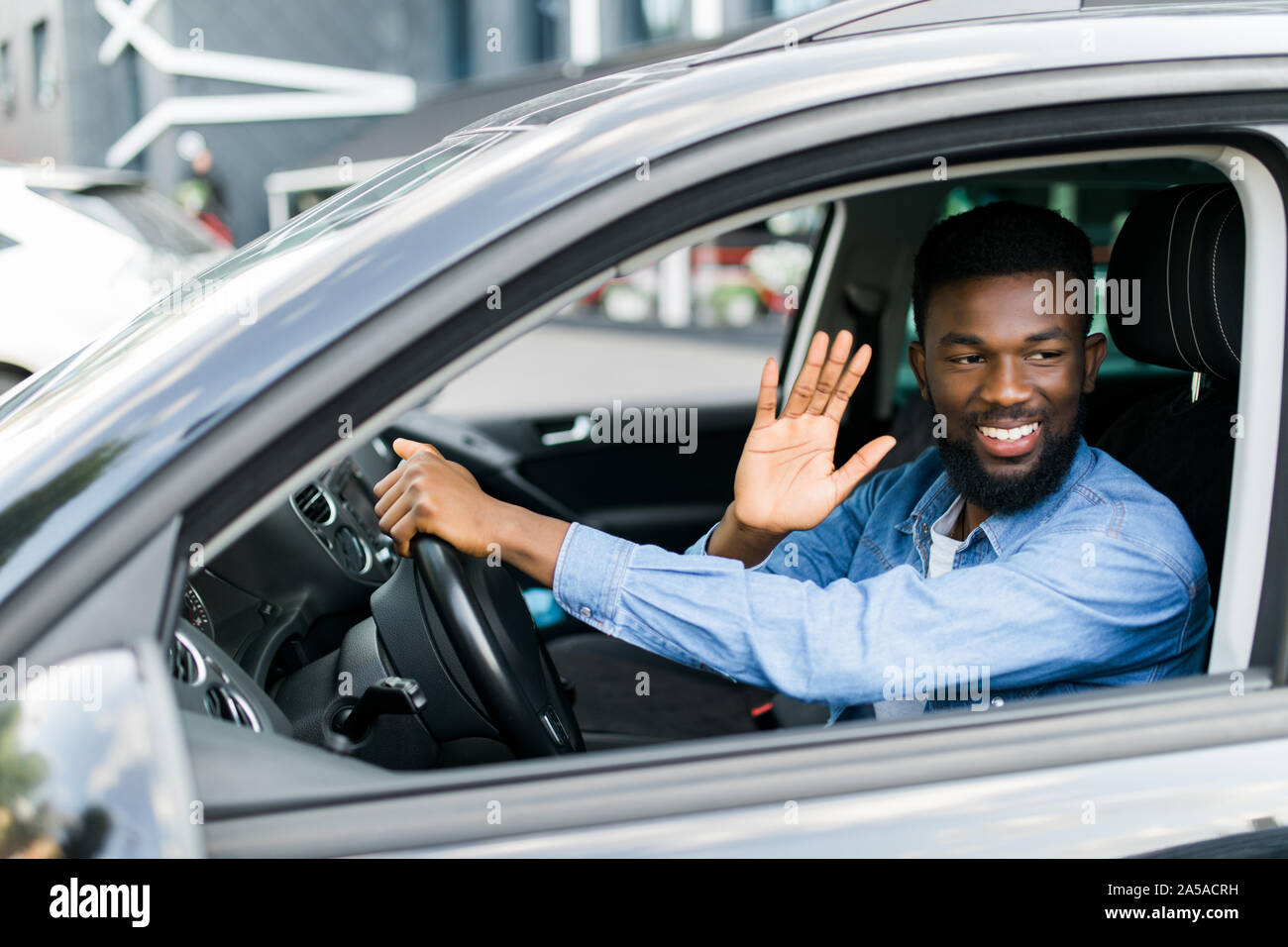 Young african man wave greetings to someone while driving his car Stock ...