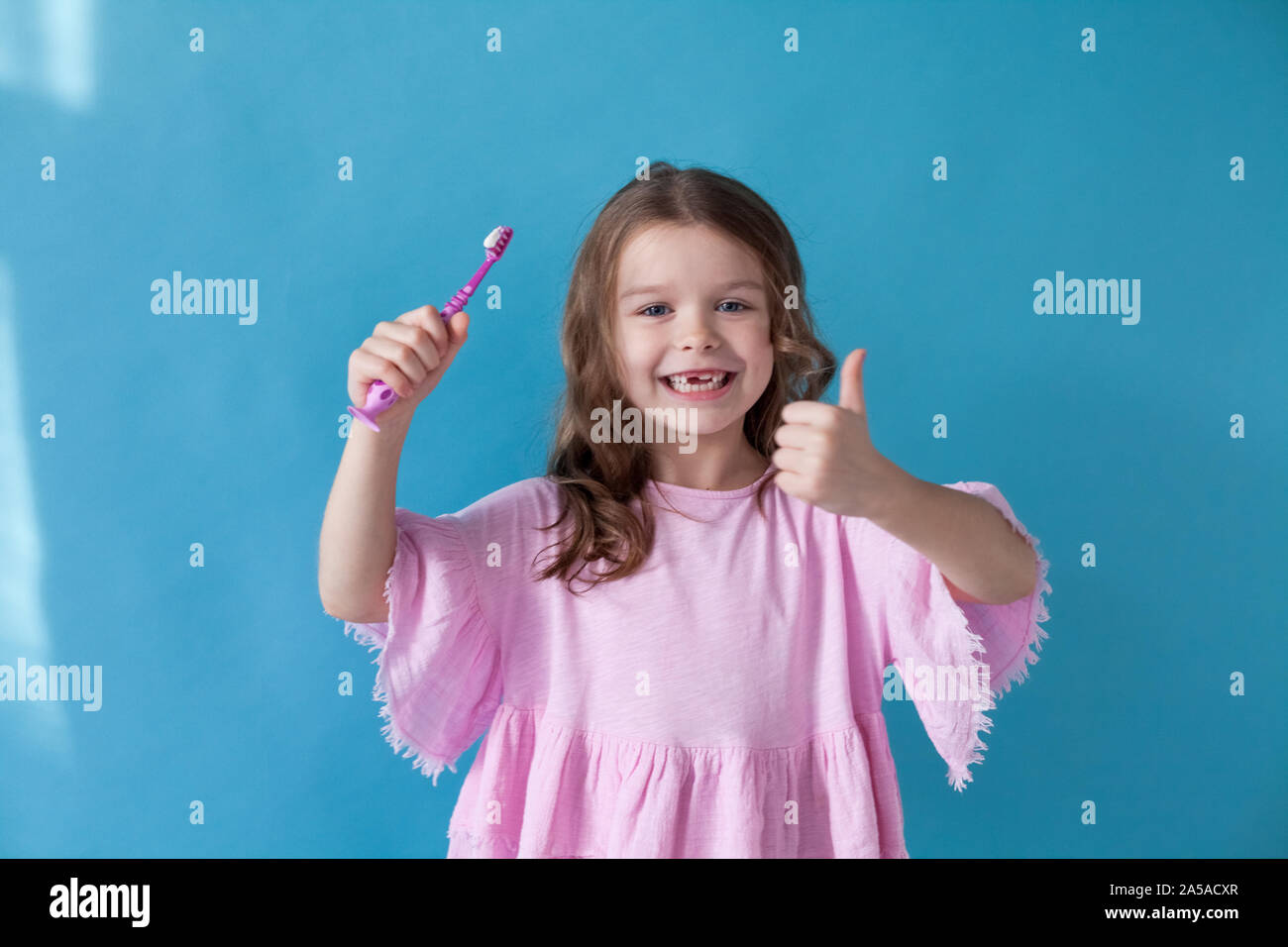 Beautiful little girl without a tooth with a toothbrush Stock Photo - Alamy