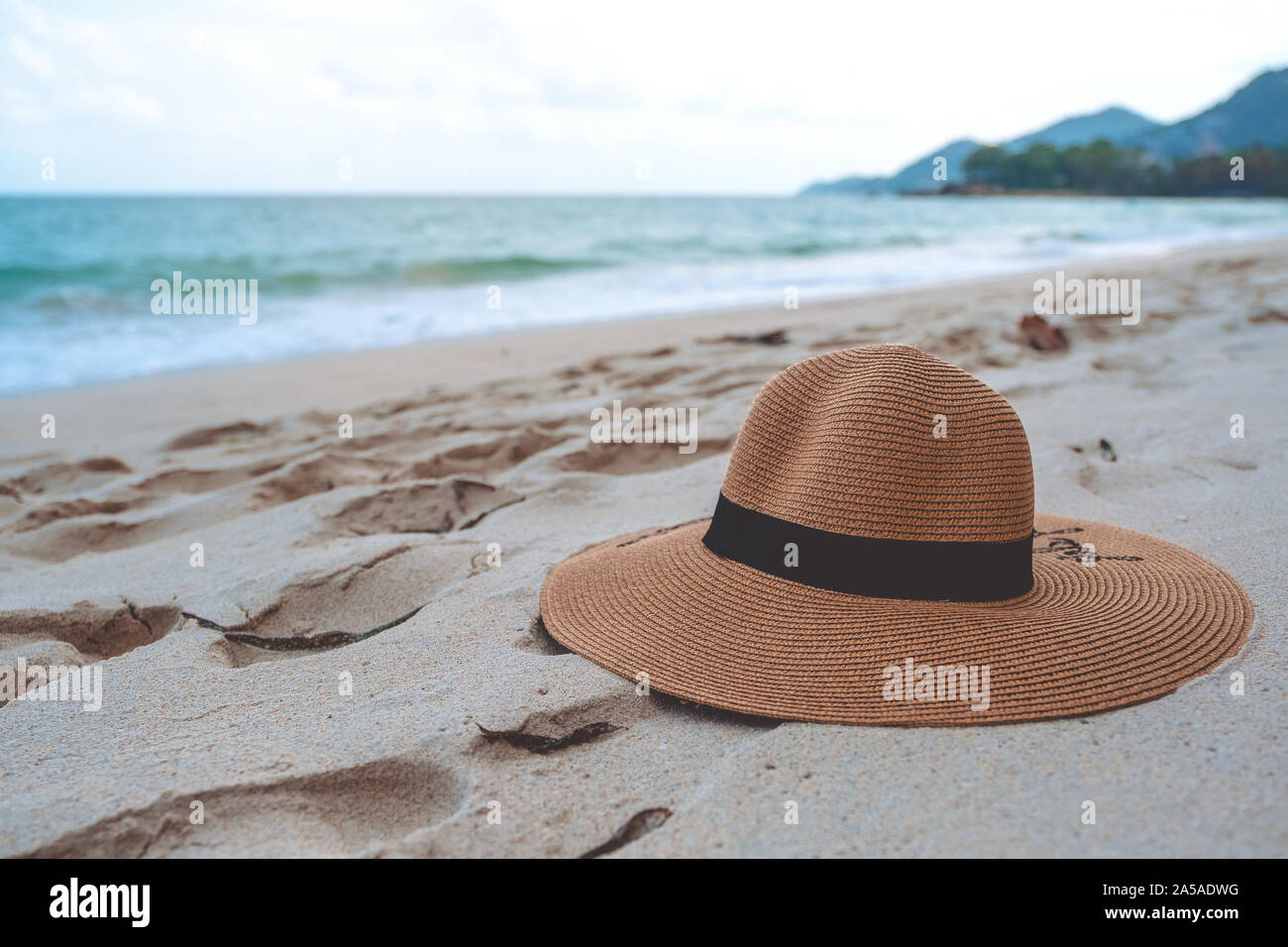 Closeup image of a beach hat on the sand by the sea with blue sky ...