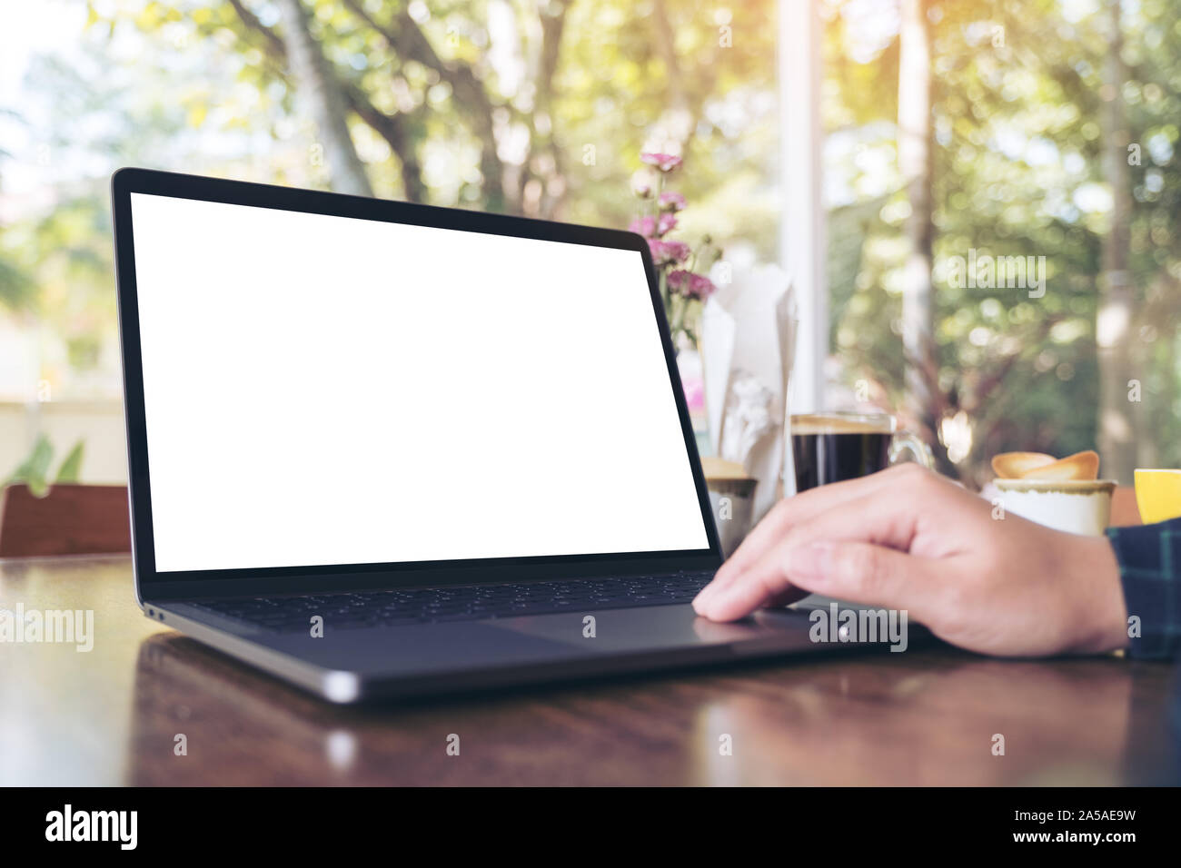Mockup image of a hand using and touching laptop with blank white ...