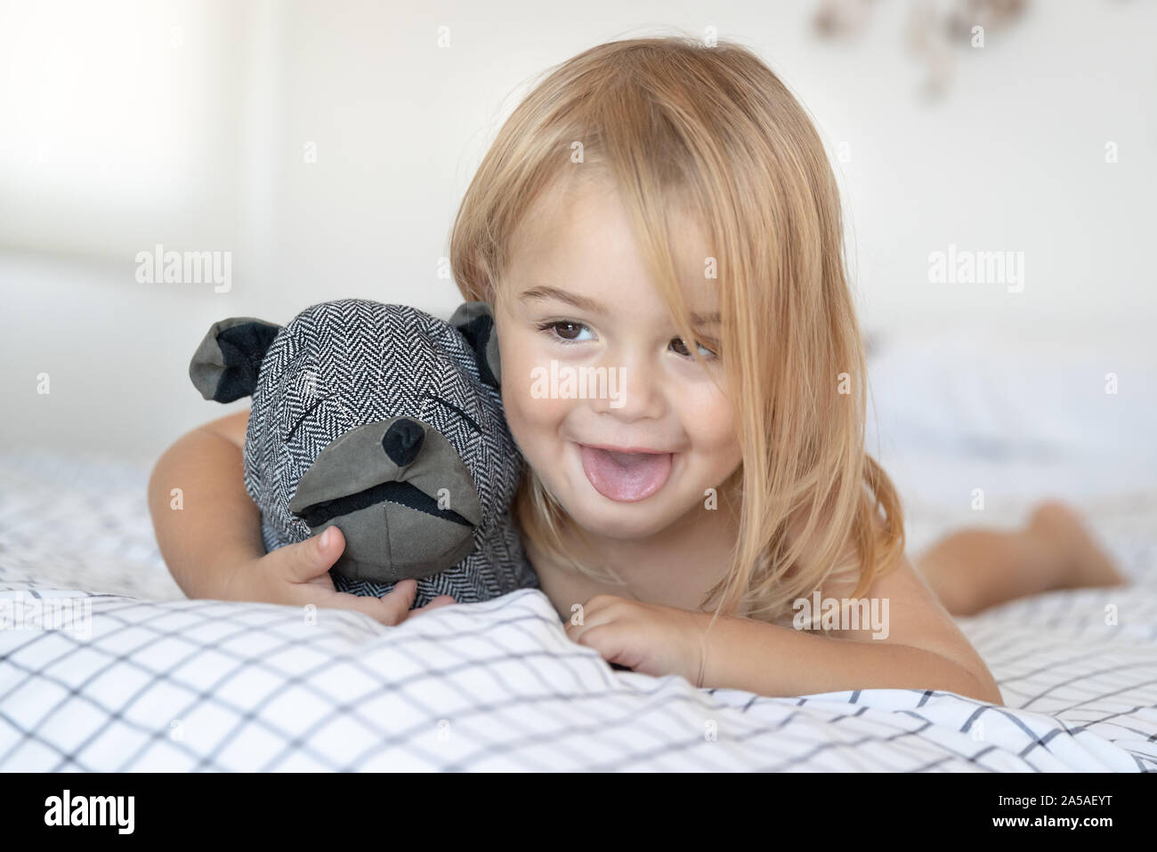 Portrait of a happy little baby boy having fun at home, lying down on ...