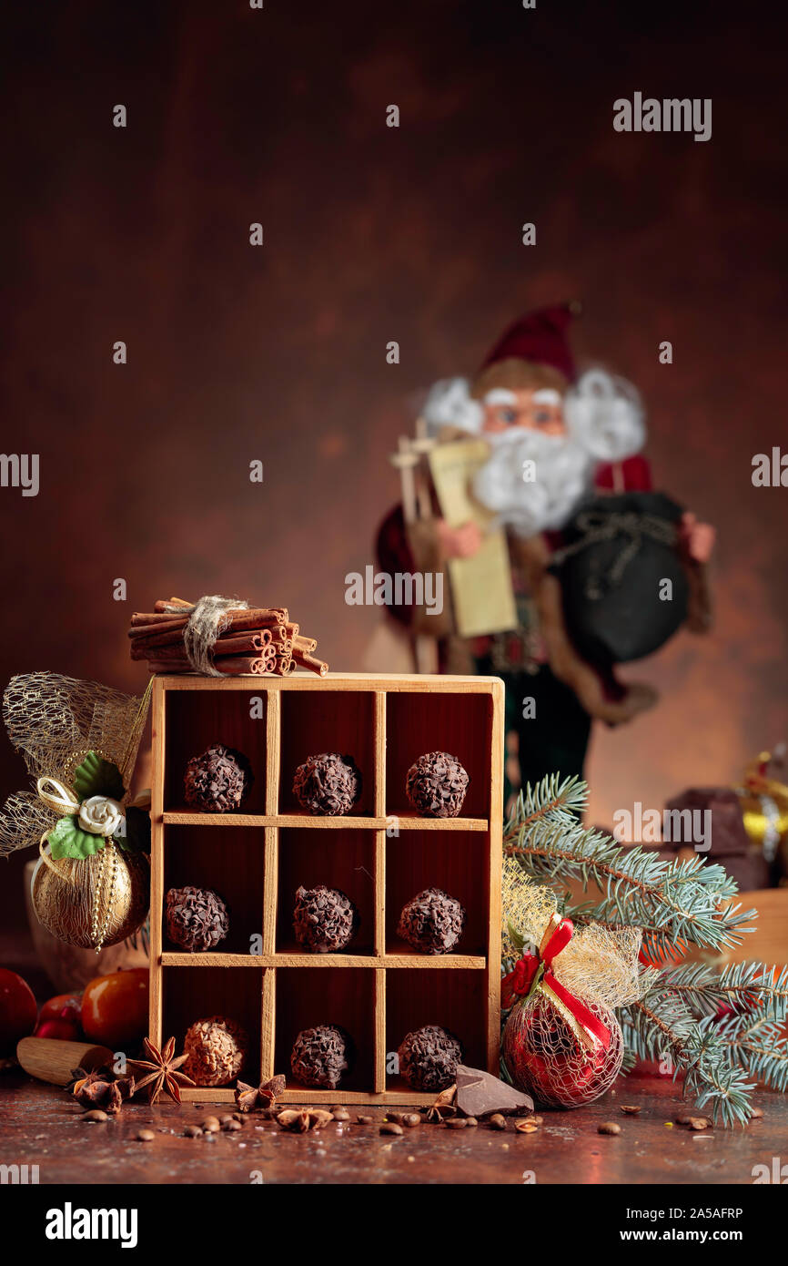 Chocolate candy in wooden box and Christmas decorations. Broken pieces ...