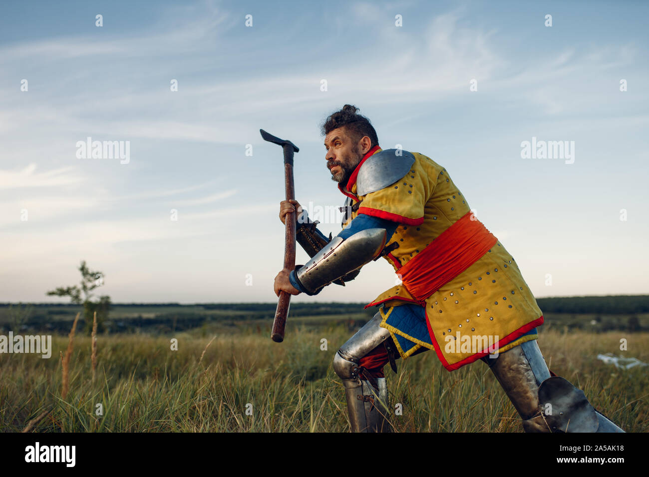 Old medieval knight in armor holds axe Stock Photo - Alamy