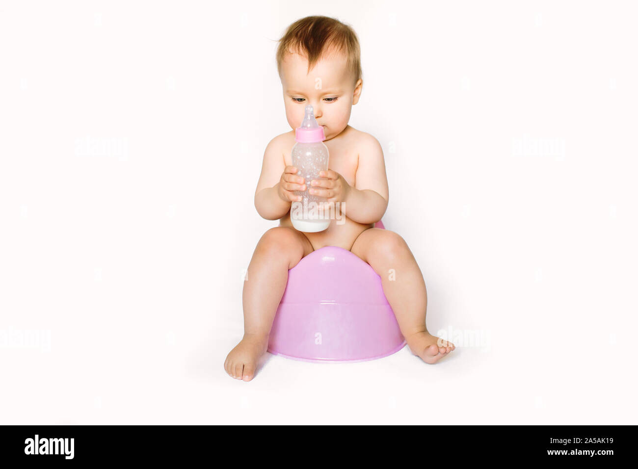Charming photo of cute baby girl holding a boottle with baby milk and ...