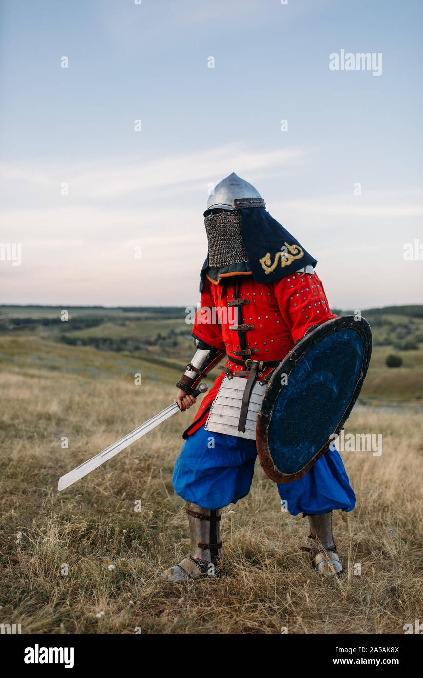 Medieval knight with sword poses in armor, fighter Stock Photo - Alamy