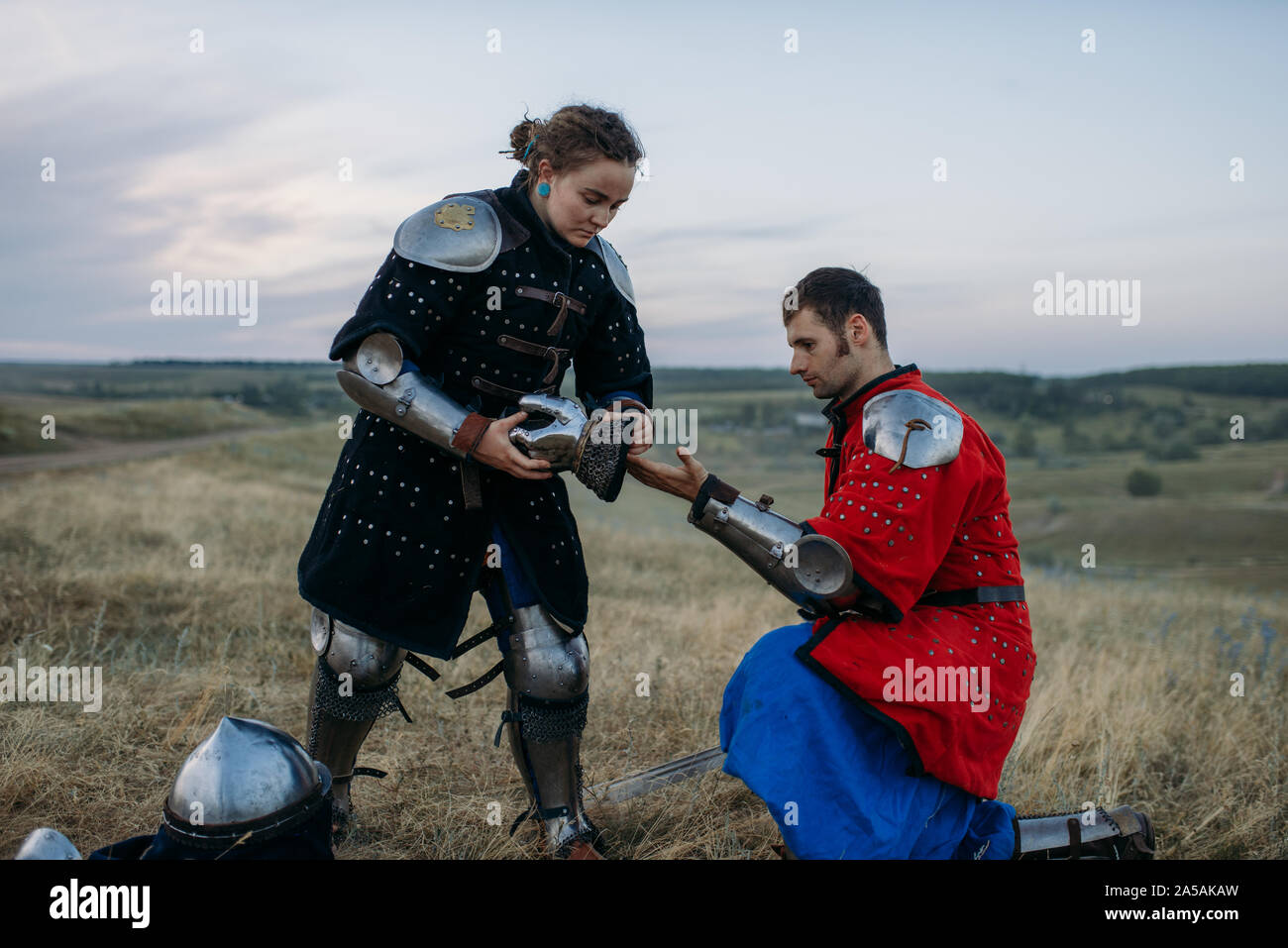 Medieval knight helps his friend to put on armor Stock Photo - Alamy
