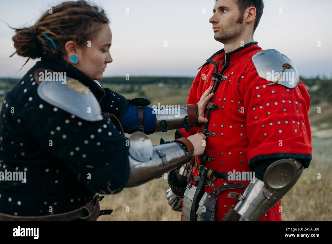 Medieval knight helps his friend to put on armor Stock Photo - Alamy