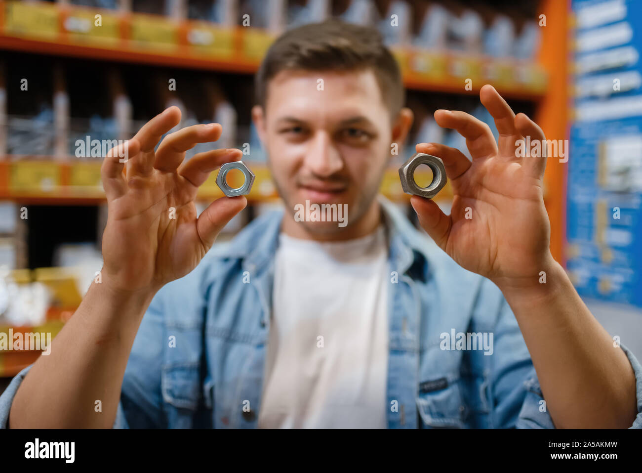 Male customer choosing nuts in hardware store Stock Photo - Alamy