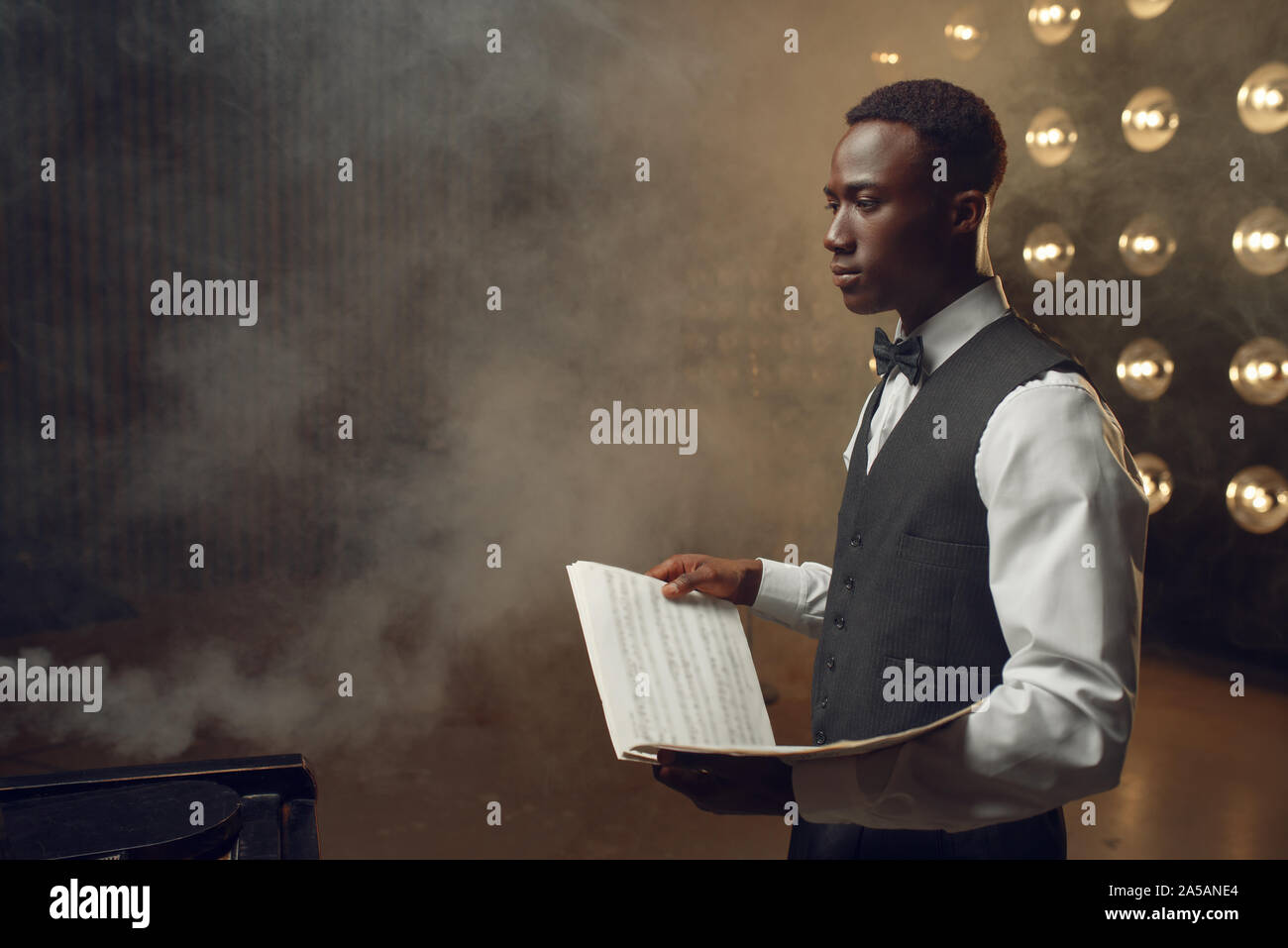Black pianist with music notebook on the stage Stock Photo - Alamy