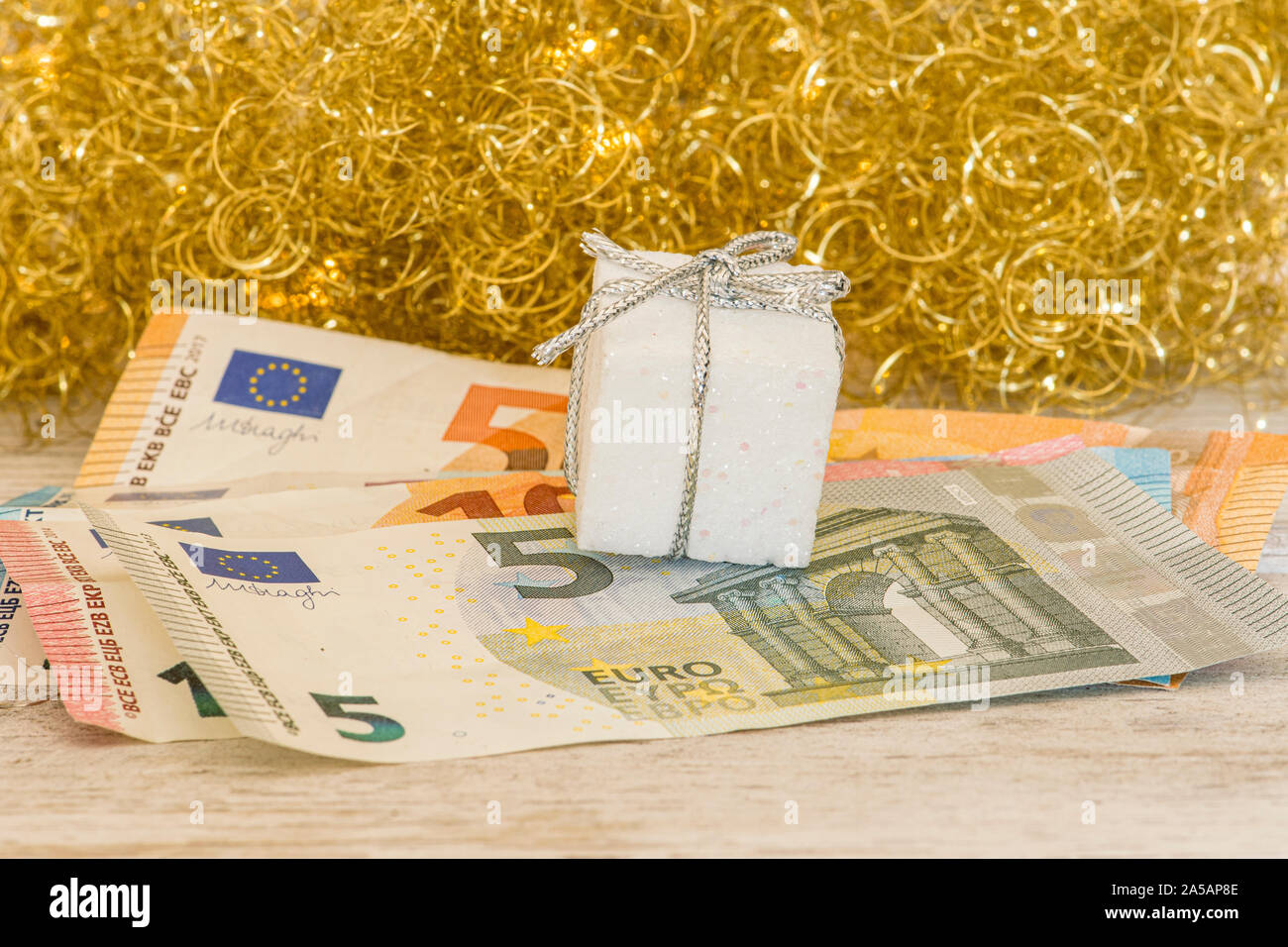 Gift with euro banknotes and golden background Stock Photo - Alamy