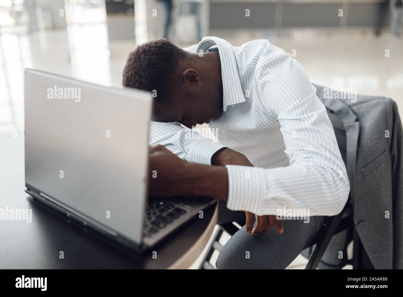 Businessman with laptop sleeping in office cafe Stock Photo - Alamy