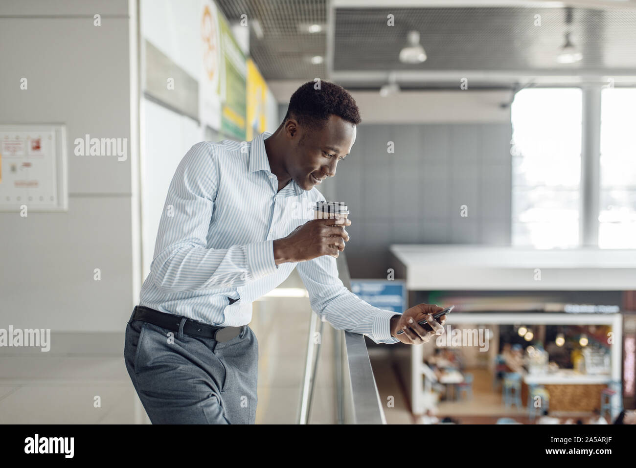 Black businessman with cup of coffee, food-court Stock Photo - Alamy