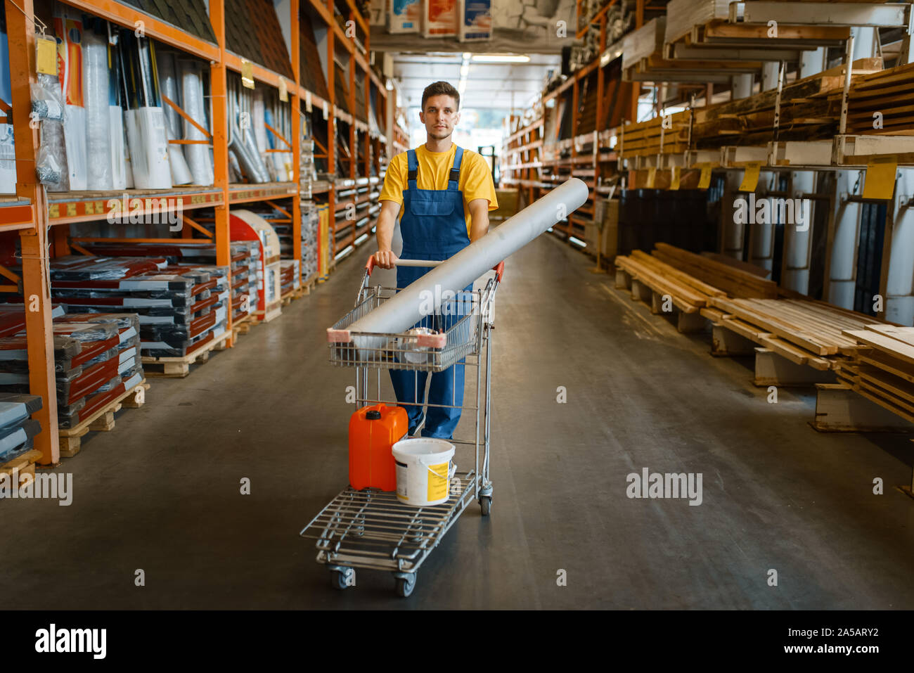 Male builder carries building materials in a cart Stock Photo - Alamy