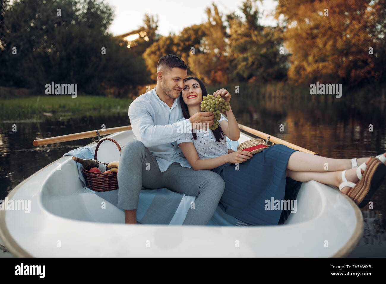 Love couple hugs in a boat on quiet lake Stock Photo - Alamy