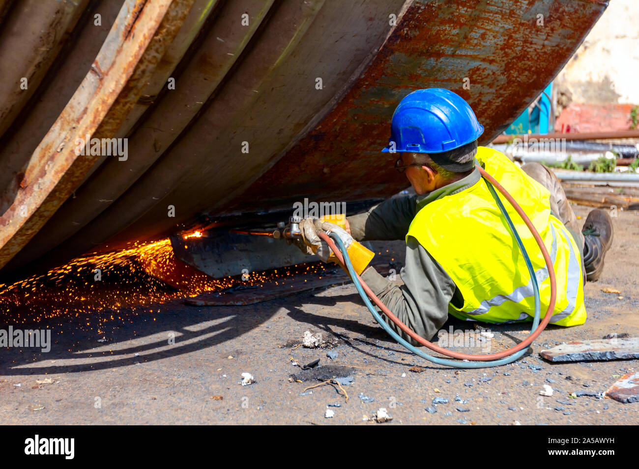 Worker is cutting manually old metal construction using gas mixture of ...