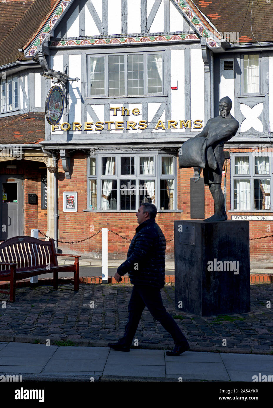 Man walking past the Foresters Arms and sculpture - the Creeler - in ...
