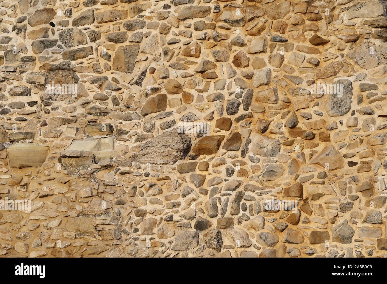 Ancient wall photographed in Cyprus. Closeup of a light brown tile wall ...