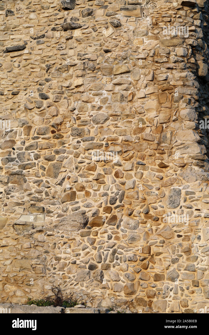 Ancient wall photographed in Cyprus. Closeup of a light brown tile wall ...