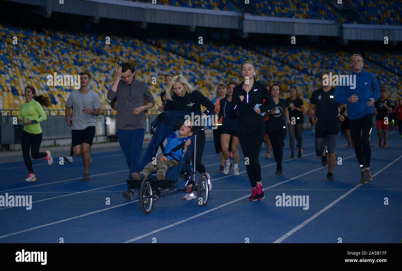 Group of people running on tracks of the stadium, in the center - woman ...