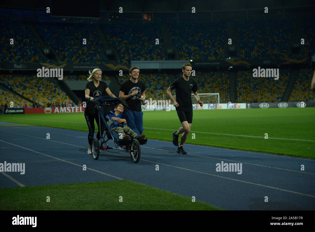Group of people running on tracks of the stadium, in the center - woman ...
