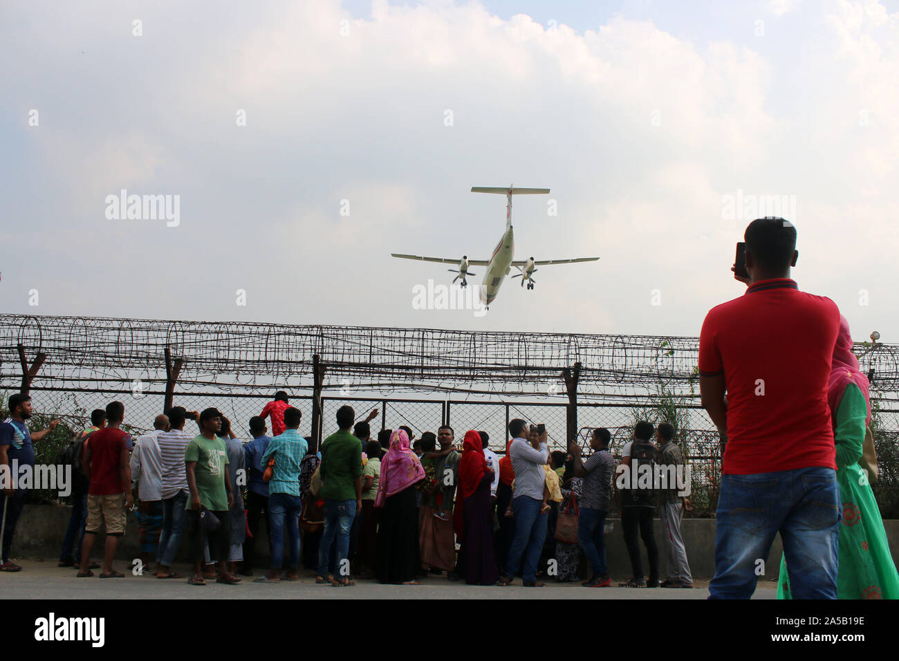 Dhaka, Bangladesh. 20th Oct, 2019. People watch an airplane flying over ...