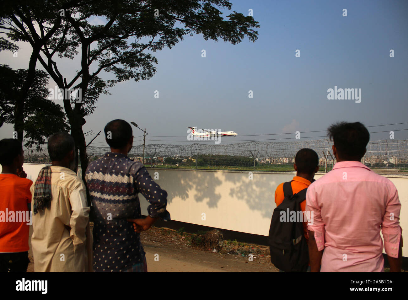 Dhaka, Bangladesh. 20th Oct, 2019. People watch an airplane flying over ...