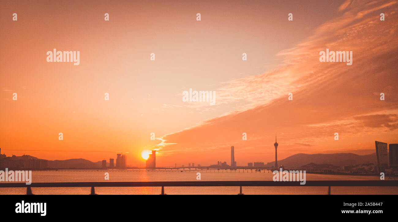Urban landscape of Macau with famous traveling tower under orange ...