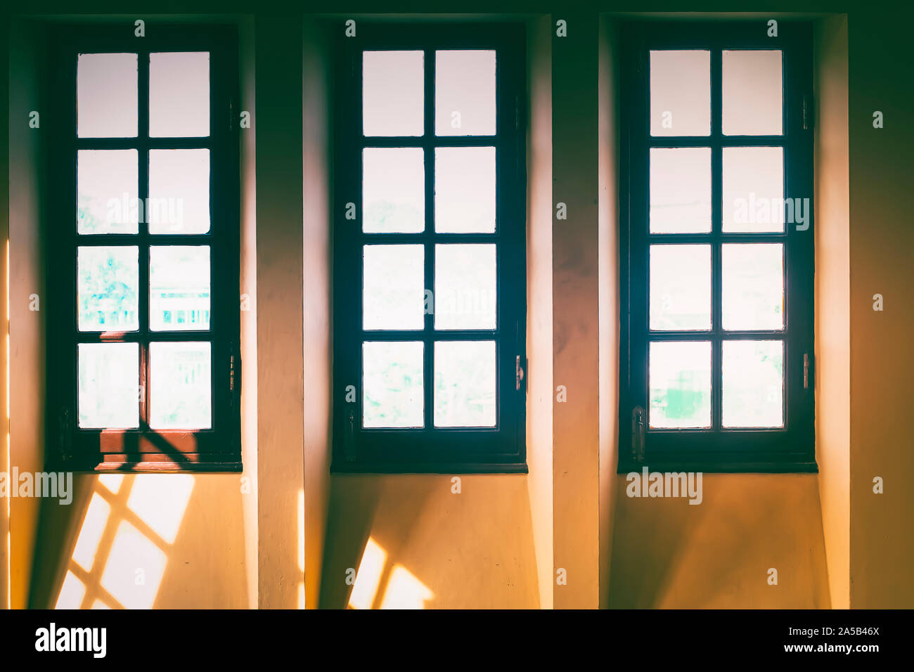 Old translucent glass with brown wooden frame window on white tone wall ...