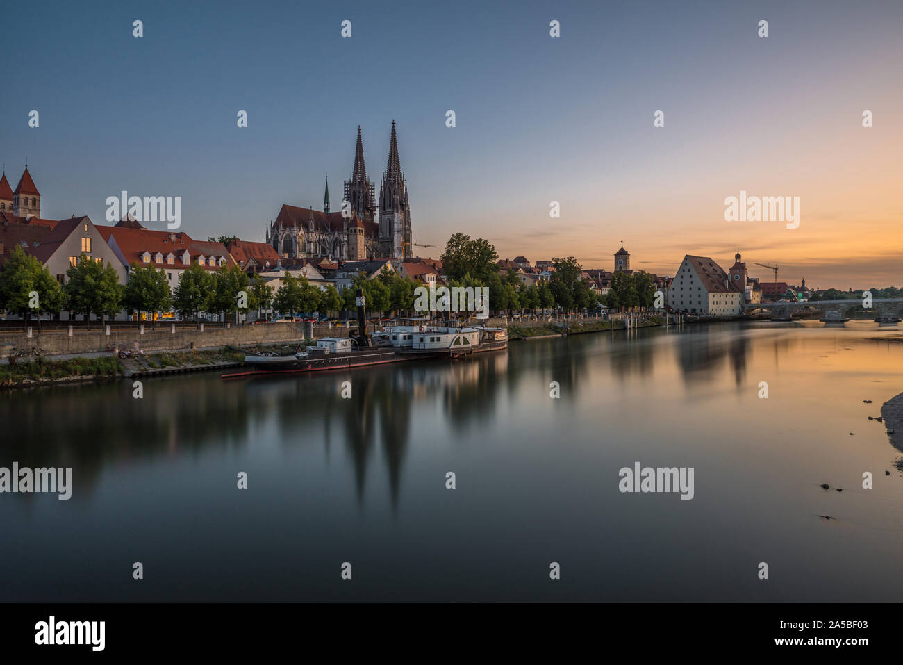Regensburg during sunset with Danube and cathedral and stone bridge ...