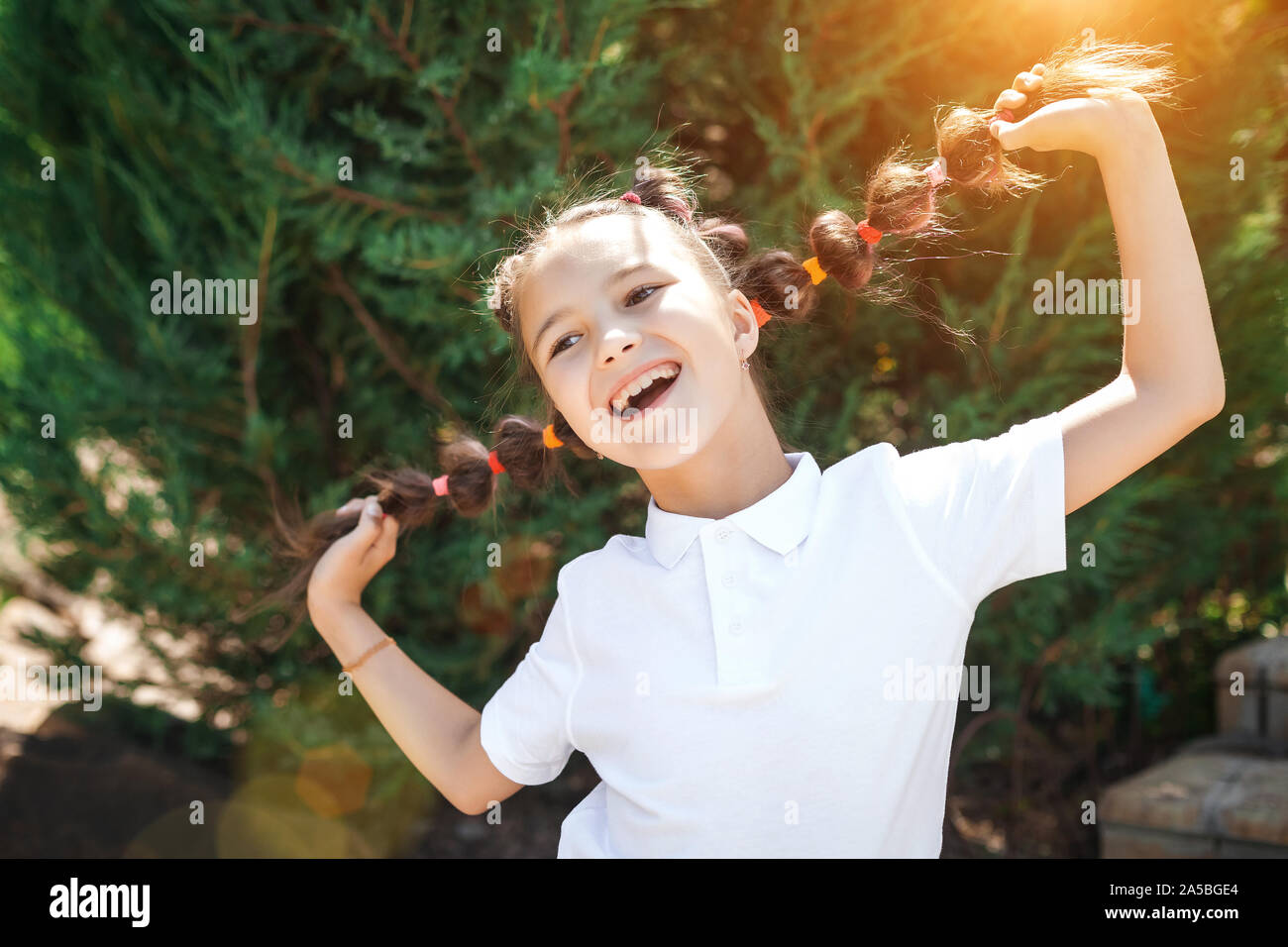 happy girl holding braids Stock Photo - Alamy