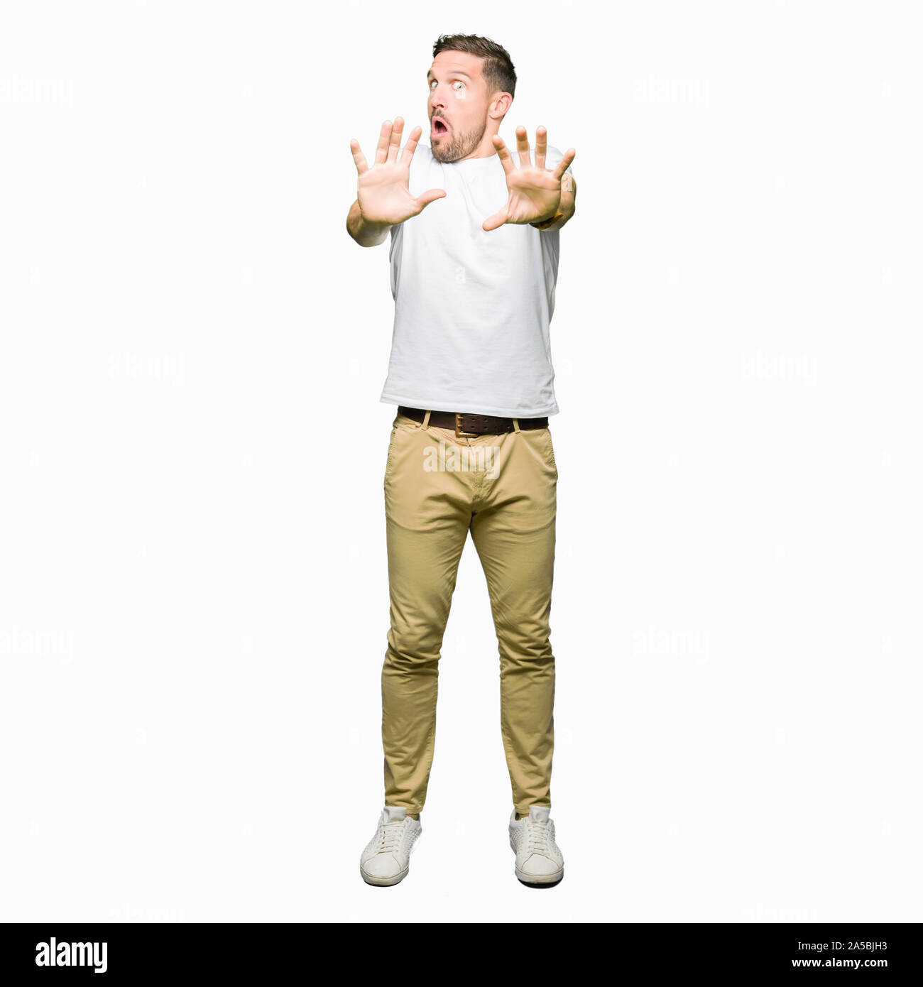 Handsome man wearing casual white t-shirt afraid and terrified with ...