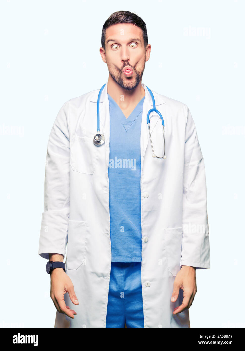 Handsome doctor man wearing medical uniform over isolated background ...