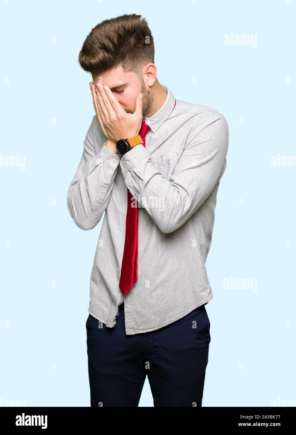 Young handsome business man with sad expression covering face with ...