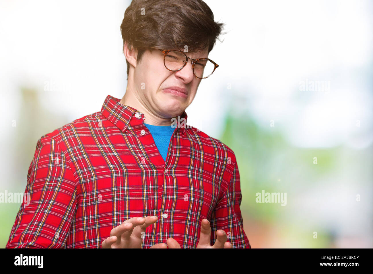 Young handsome man wearing glasses over isolated background disgusted ...