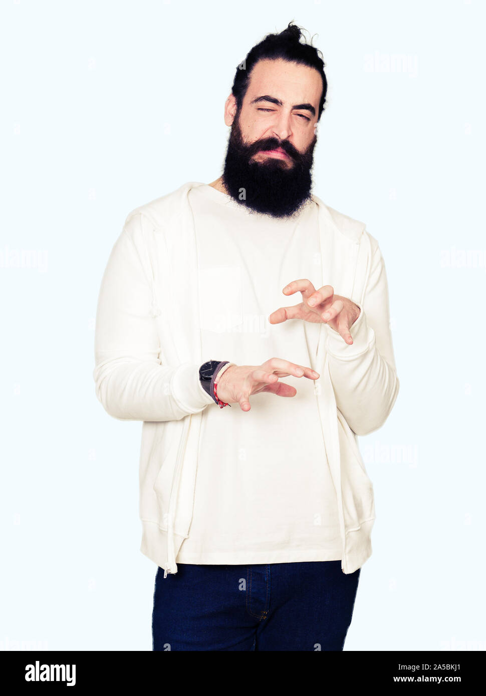 Young man with long hair and beard wearing sporty sweatshirt disgusted ...