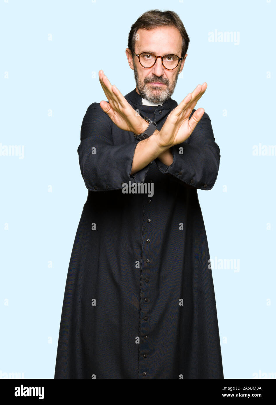 Middle age priest man wearing catholic robe Rejection expression ...