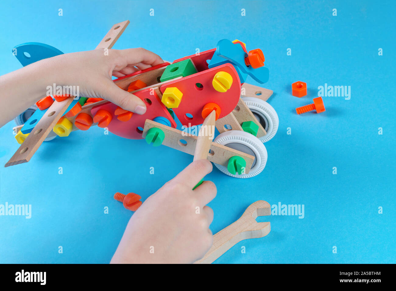 child playing with constructor and make a plain, blue background ...