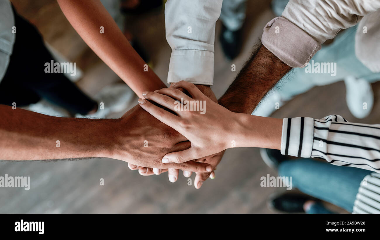 Cooperation. Top view of people holding hands together while standing ...