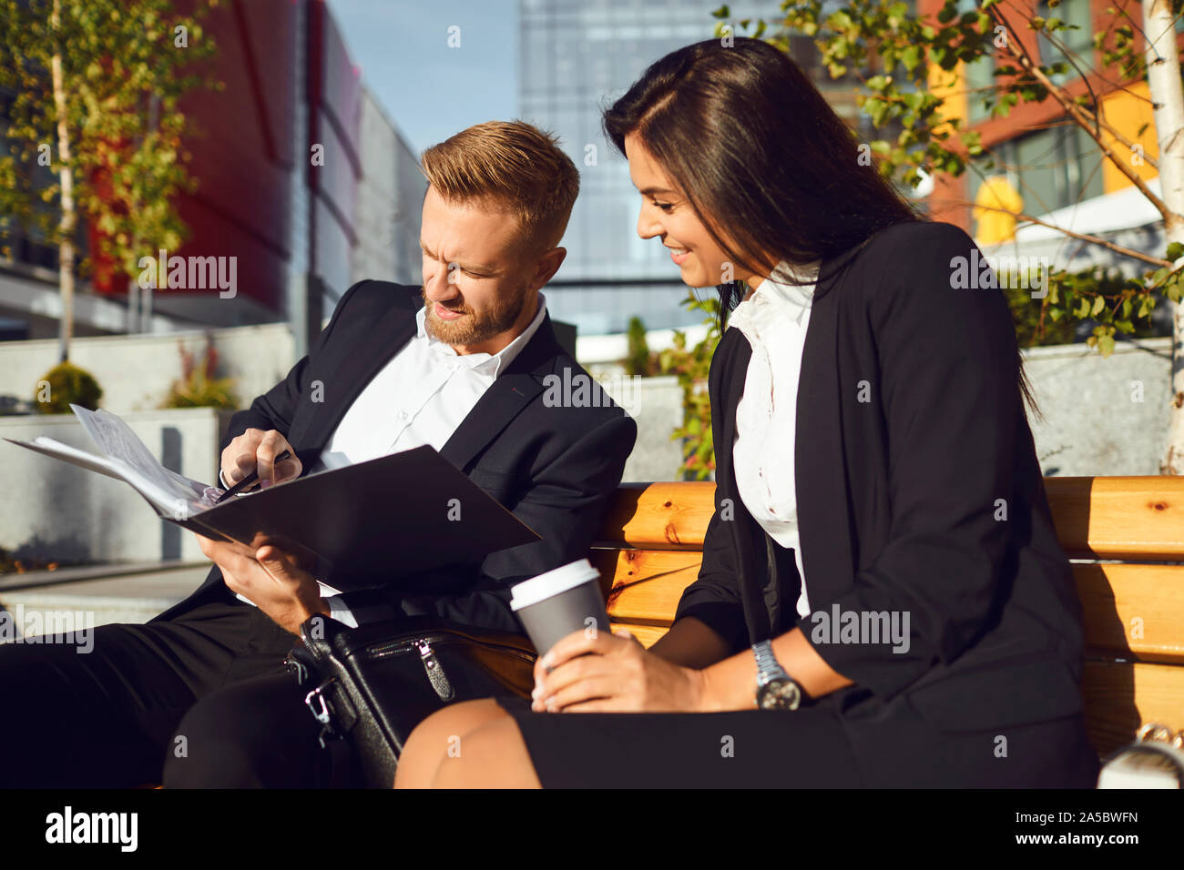 Business people read sign documents sitting on a city street Stock ...