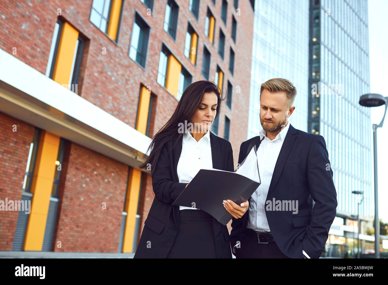 Business people read sign documents standing on a city street Stock ...