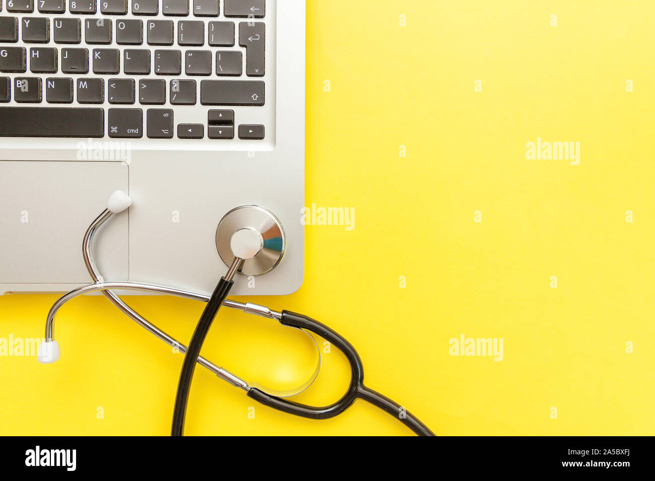 Stethoscope keyboard laptop computer isolated on yellow background ...