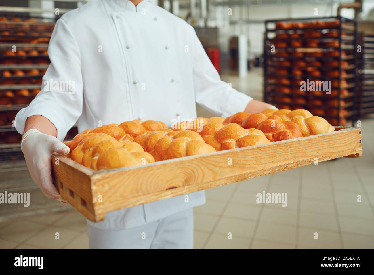 Baker's hands hold a tray with fresh bread. Bakery concept Stock Photo ...