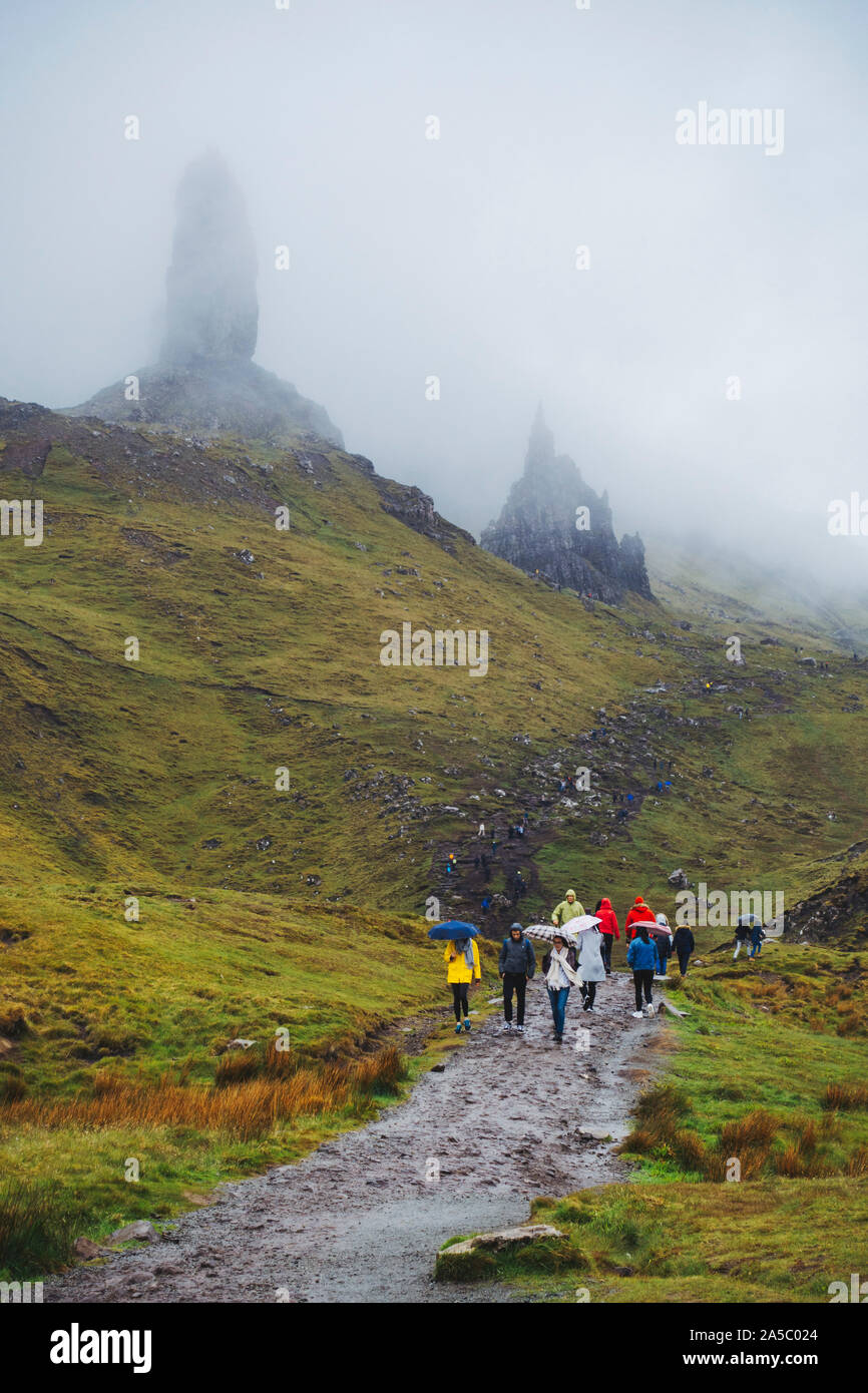 Tourists don raincoats and umbrellas on a rainy, cloudy day at the Old ...