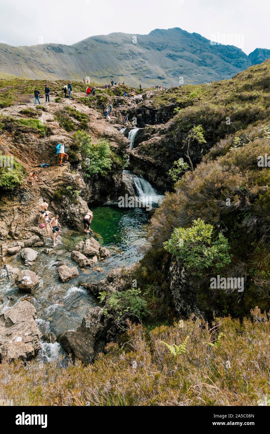 Tourists swim and clamber over waterfalls and rocks at the Fairy Pools ...