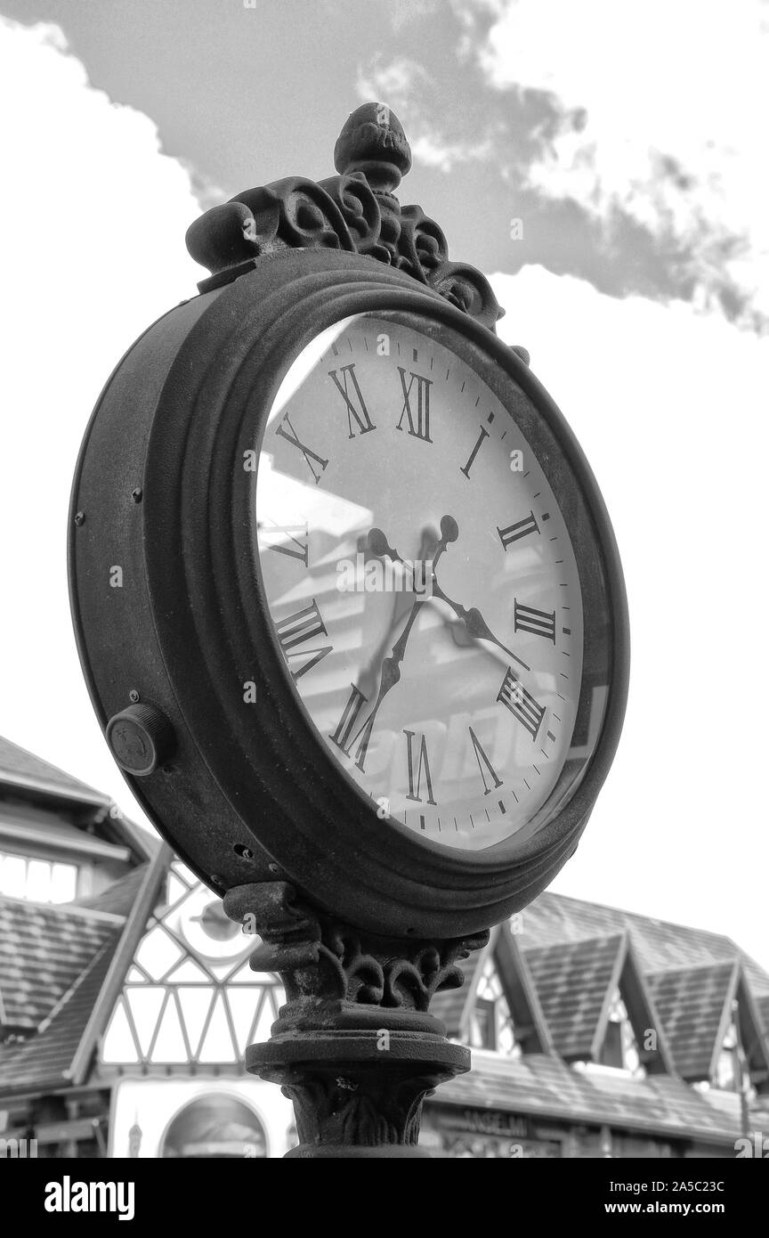 Vertical grayscale of a steel analog clock on a pole on a street Stock ...