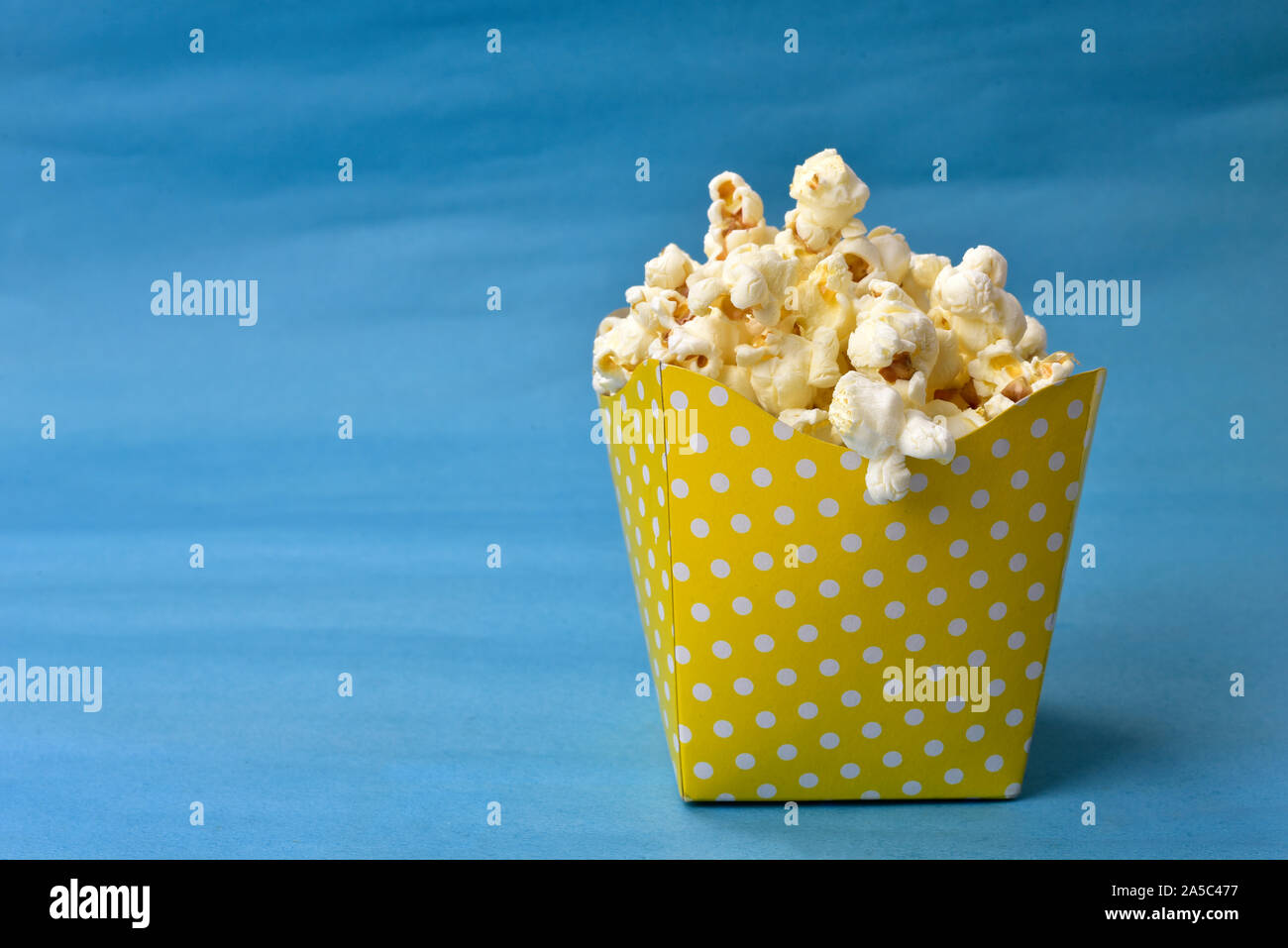 popcorn falling from paper packaging with blue background Stock Photo ...