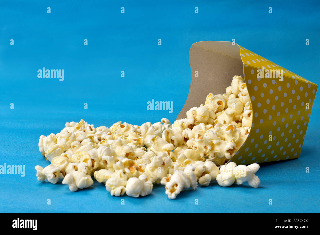 popcorn falling from paper packaging with blue background Stock Photo ...