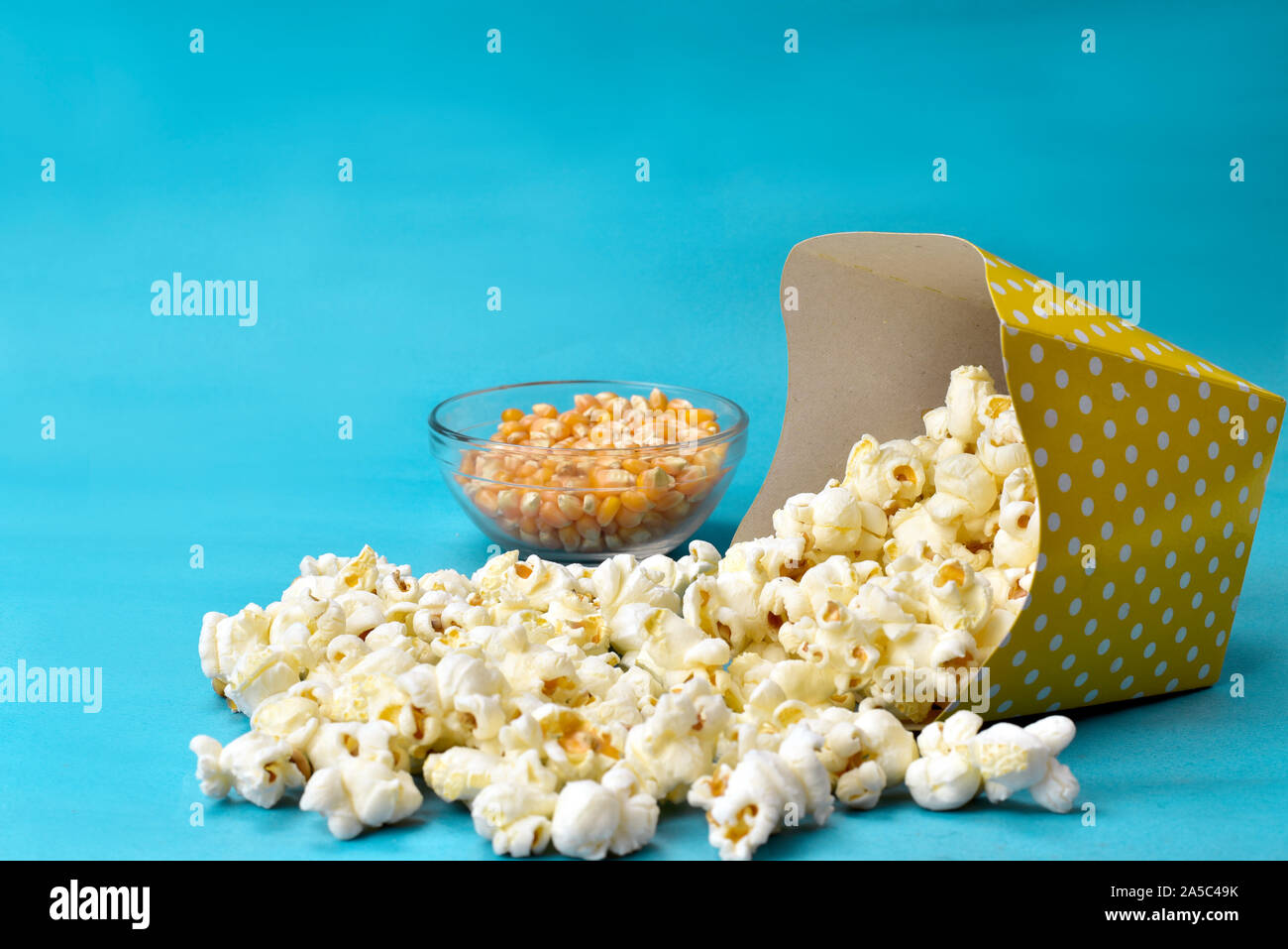popcorn falling from paper packaging with blue background Stock Photo ...