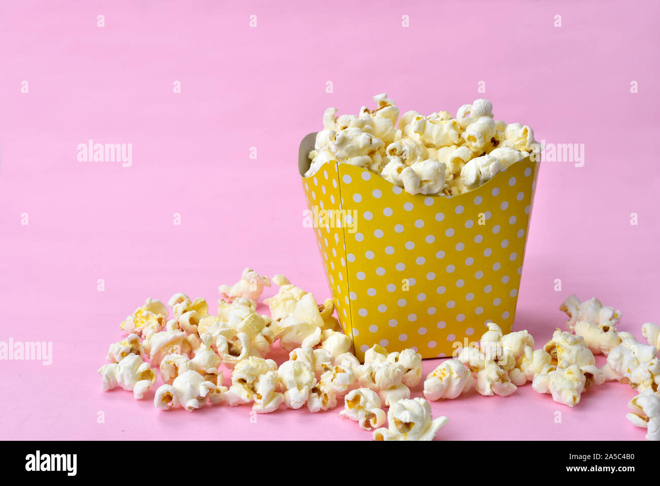 popcorn falling from paper packaging with pink background Stock Photo ...