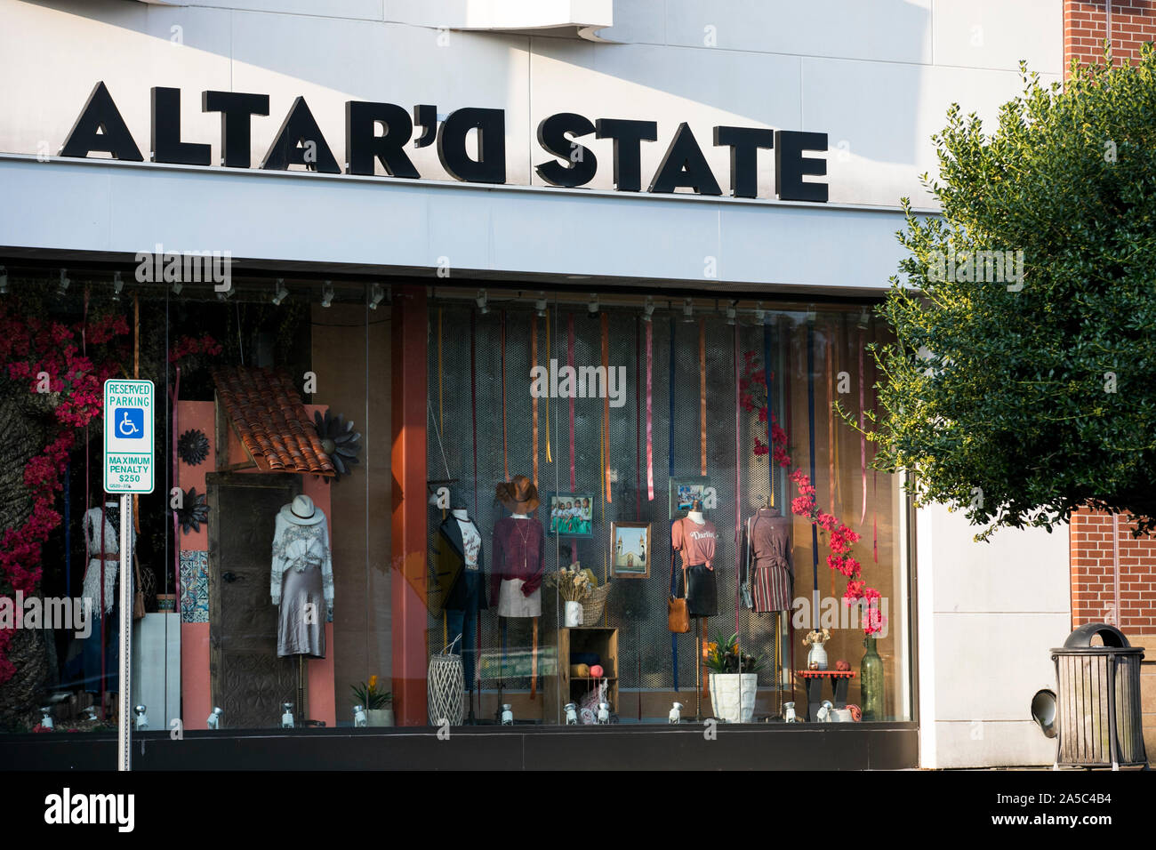 A logo sign outside of a Altar'd State retail store location in ...